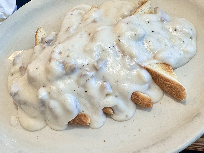 Behold the biscuits and gravy that inspired this entire article – fluffy clouds drowning in creamy, sausage-studded perfection.