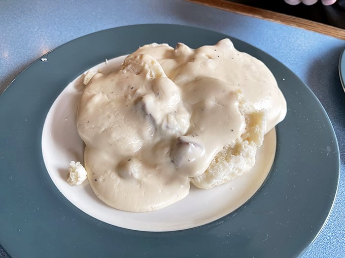 Behold the holy grail of breakfast – biscuits drowning in creamy sausage gravy that would make your grandmother simultaneously proud and jealous.