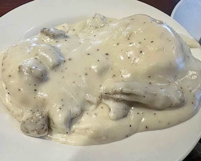 Biscuits and gravy so heavenly they should come with their own choir – creamy, peppery perfection blanketing fluffy clouds of dough.