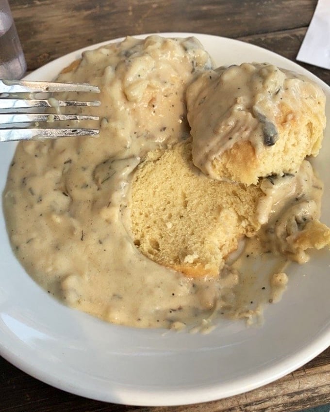 These biscuits and gravy aren't just breakfast—they're an edible hug. Golden, fluffy islands swimming in a sea of peppery, herb-flecked gravy.