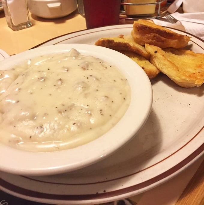 Behold the holy grail of comfort food – sausage gravy cascading over buttermilk biscuits like a creamy waterfall of happiness. Worth every napkin.