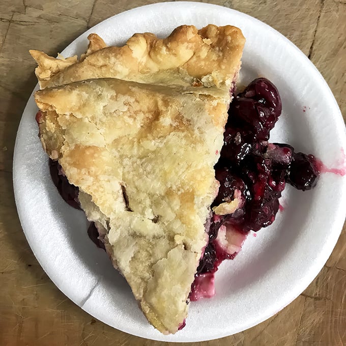This slice of blueberry heaven might be the real reason locals keep coming back—a golden-crusted masterpiece bursting with juicy, purple perfection.