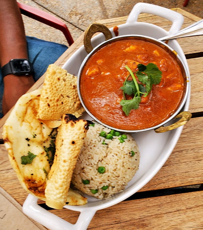 This isn't just butter chicken—it's a hug in a bowl, served with perfectly fluffy rice and naan that's begging to soak up that velvety sauce.