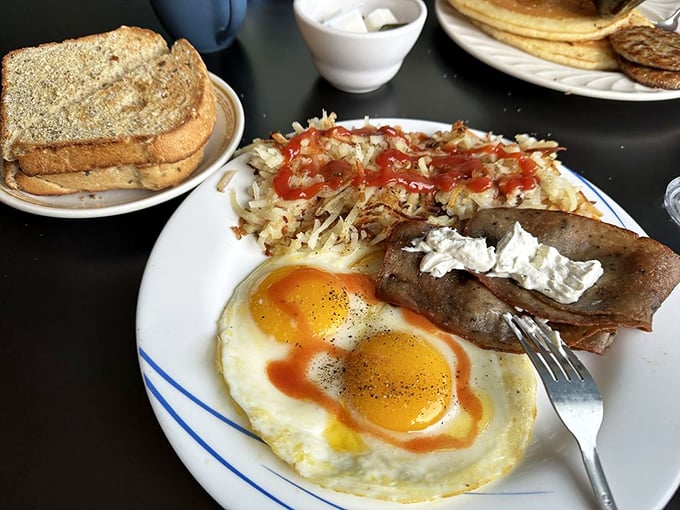 Sunny-side up eggs with that perfect runny yolk, crispy home fries with just the right amount of ketchup—this is breakfast architecture at its finest.