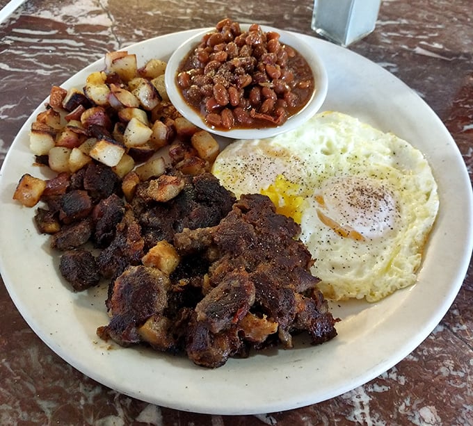 Breakfast nirvana arrives on a single plate: crispy home fries, savory corned beef hash, and eggs cooked exactly how you specified—a morning masterpiece.