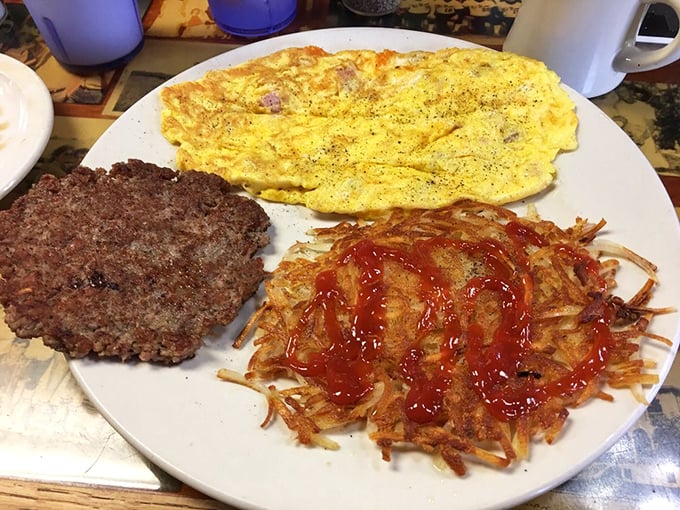 Breakfast of champions, Oklahoma-style! That fluffy omelet, crispy hash browns with ketchup, and burger patty create the holy trinity of morning satisfaction.