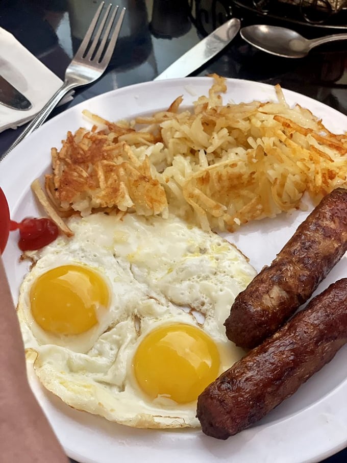 Sunny-side up eggs with that perfect runny yolk, crispy hash browns, and sausage links—the breakfast trinity that never disappoints.