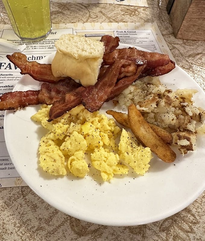 Breakfast perfection on a plate: golden scrambled eggs, bacon that's achieved that mythical balance between crisp and chewy, and home fries that demand to be devoured.