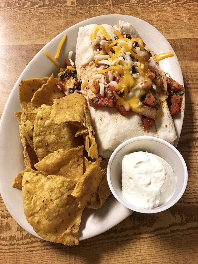 The Breakfast Burrito arrives like a gift from the morning gods—tortilla-wrapped treasures with local chips standing guard.