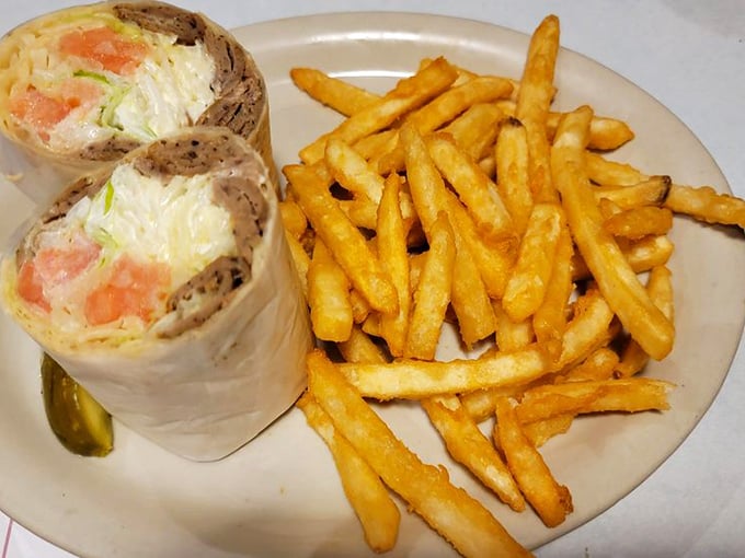 Behold the breakfast wrap in all its glory – eggs, cheese, and veggies bundled like precious cargo in a tortilla, with those golden fries standing at attention.