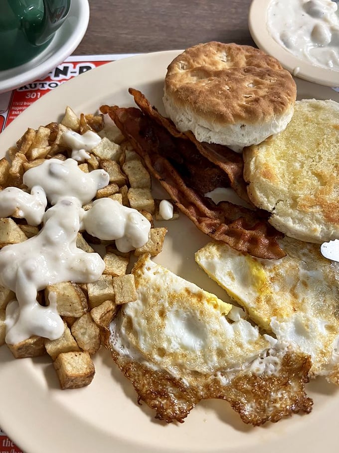 Two eggs, bacon, biscuit, and gravy-topped home fries: proof that some mornings require the full treatment.