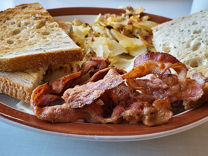 Crispy bacon that shatters like glass, golden home fries, and toast that's actually buttered properly—breakfast fundamentals executed with respect.