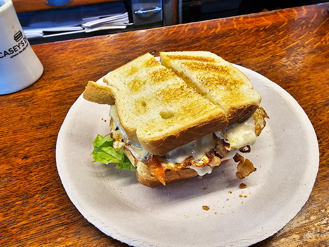 Sandwich architecture at its finest! Melty cheese cascades over perfectly fried eggs between golden toast—a breakfast masterpiece.