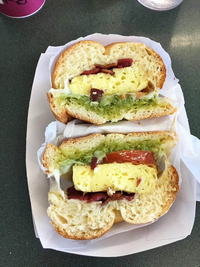 The legendary breakfast sandwich in all its glory—perfectly cooked eggs, vibrant pesto, and bread that deserves its own fan club.