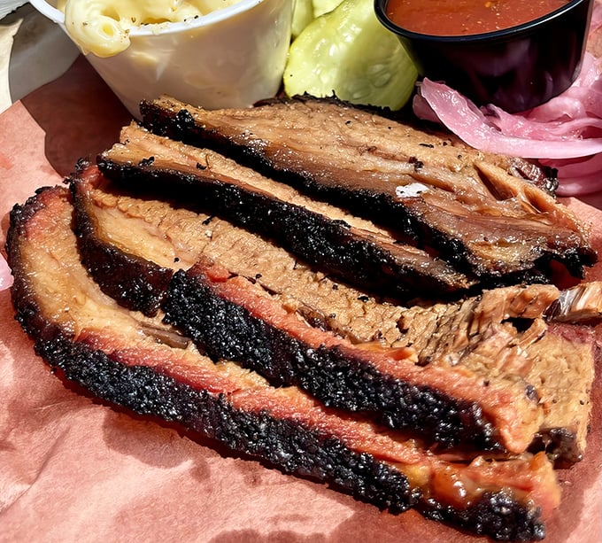 Behold the holy grail of barbecue—brisket with that perfect pink smoke ring and bark that would make a Texas pitmaster weep with joy.
