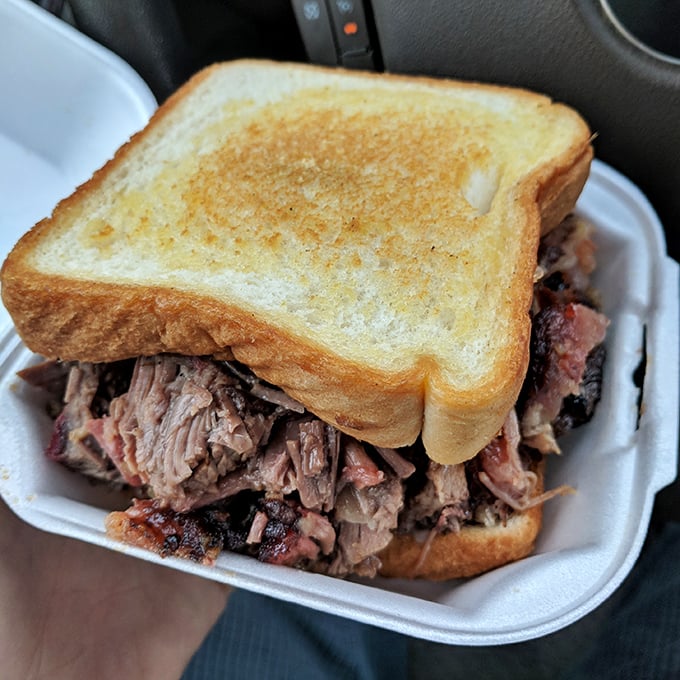 Behold the brisket sandwich in all its glory! Perfectly smoked meat spilling from between golden garlic toast – car dining never looked so good.