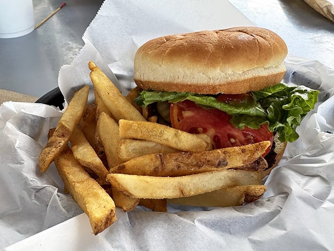This isn't just a burger; it's edible proof that simplicity triumphs over pretension. Golden fries standing guard beside their beefy commander-in-chief.