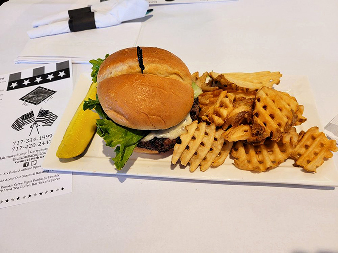 This isn't just a burger; it's edible architecture – a perfectly stacked masterpiece with waffle fries that deserve their own monument on the battlefield.