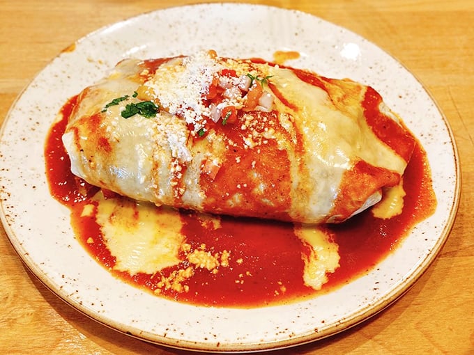 This isn't just any burrito—it's a masterpiece wrapped in a tortilla, swimming in vibrant sauce and topped with a snowfall of queso fresco.