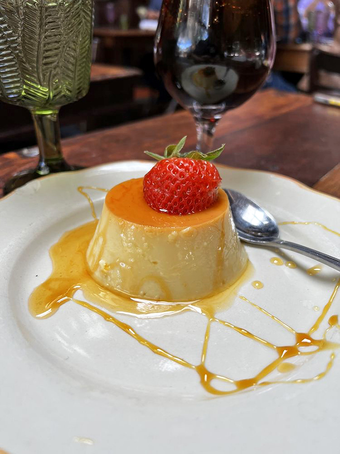 Here it is, folks—the flan that launched a thousand return visits, crowned with a strawberry like culinary royalty.