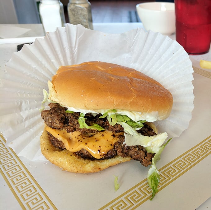 Behold the masterpiece: a cheeseburger so substantial it requires architectural engineering to consume properly.
