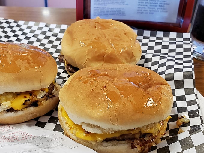 Three perfect cheeseburgers on their classic checkered paper—like a chess match where your taste buds always win, no matter which one you choose.