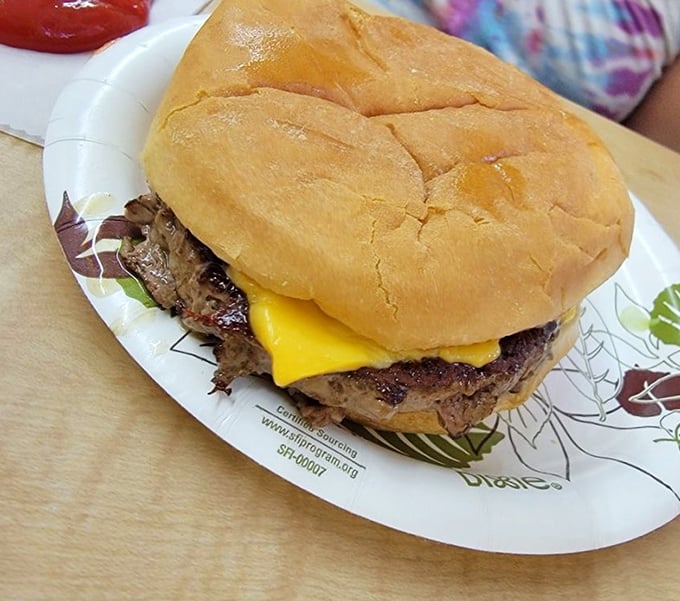Behold the star of the show—a cheeseburger that refuses to be contained by its bun. This golden-seared patty doesn't need Instagram filters to look delicious.
