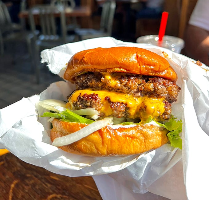 Behold the Double Cavern Burger in all its glory—where cheese cascades down hand-formed patties like a yellow lava flow of deliciousness.