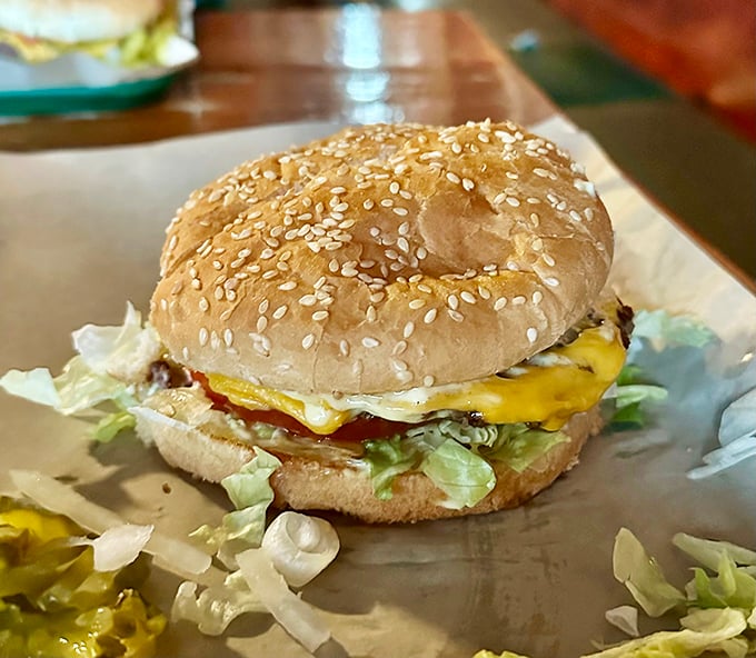 The star of the show: a perfectly constructed cheeseburger on a sesame seed bun. No foam, no deconstruction, no nonsense—just pure American happiness.