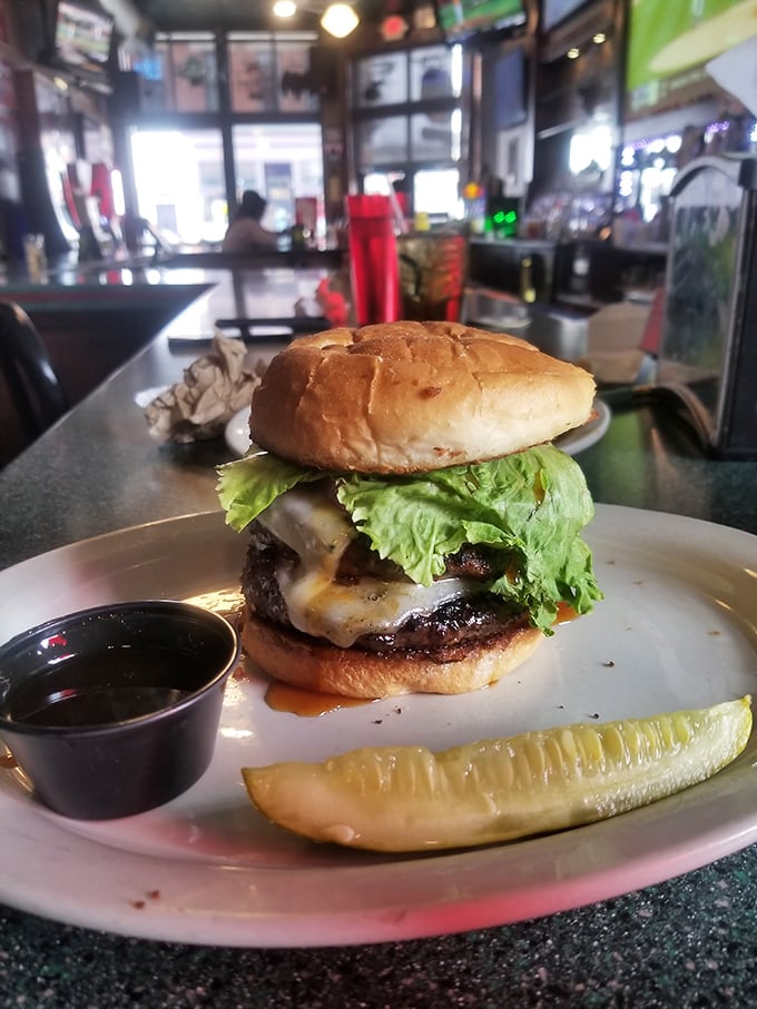 This isn't just a burger; it's a masterclass in simplicity—juicy patty, melted cheese, fresh lettuce, and a pickle spear standing guard like a delicious sentinel. 