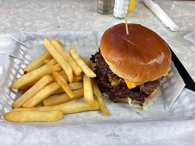 Behold the star of the show – a perfectly smashed burger with those coveted crispy edges that extend beyond the bun like a meaty solar eclipse.