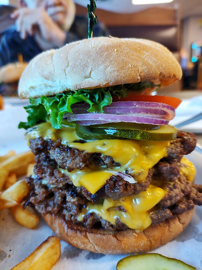 Behold the tower of power! This multi-patty masterpiece with melted cheese cascading down like a yellow waterfall demands both respect and napkins.