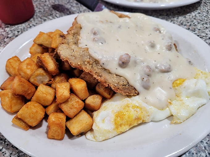 Behold the star of the show: golden chicken fried steak drowning in gravy with perfectly crispy hash browns.