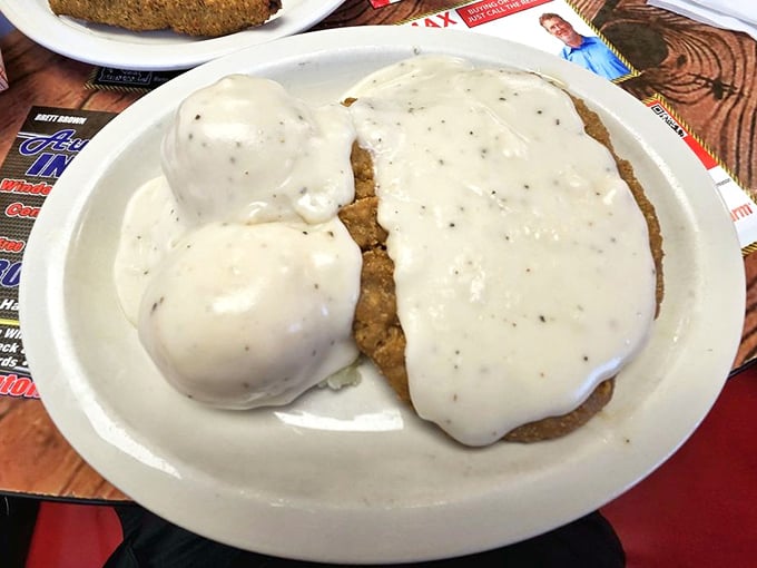 Behold the crown jewel: chicken fried steak swimming in pepper-flecked gravy alongside pillowy mashed potatoes. This isn't just dinner—it's an Oklahoma heirloom on a plate.