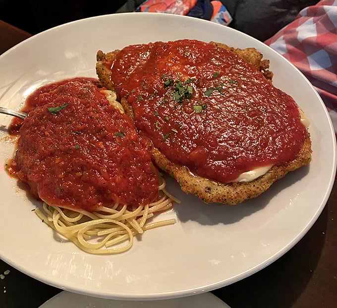 Behold the chicken parm in all its glory – a masterpiece of crispy, saucy, cheesy perfection that makes you want to cancel all other dinner plans forever.