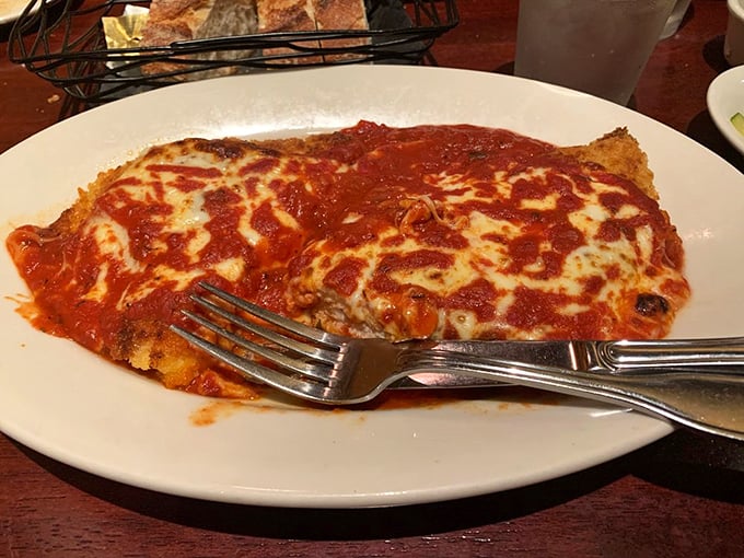 Behold the star attraction: chicken parmigiana that achieves the impossible balance of crispy exterior and tender interior, all beneath a blanket of melted cheese perfection.