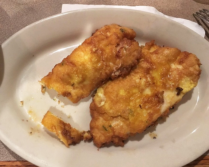 Behold the star attraction: Chicken Romano in all its golden glory. That cheese crust shatters like delicate glass, revealing juicy chicken beneath—a textural masterpiece.