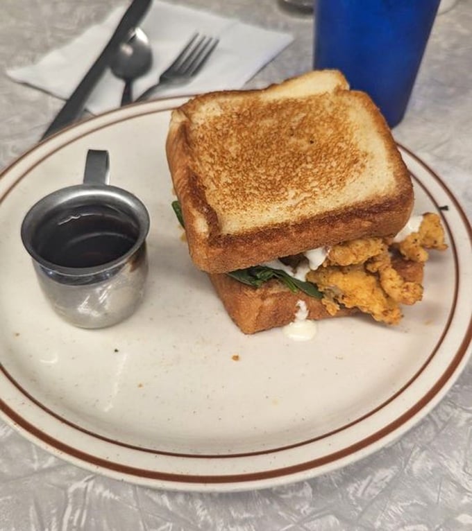 The legendary chicken sandwich in all its glory—golden toast hugging crispy fried chicken with fresh greens peeking out, served with a side of pure happiness.