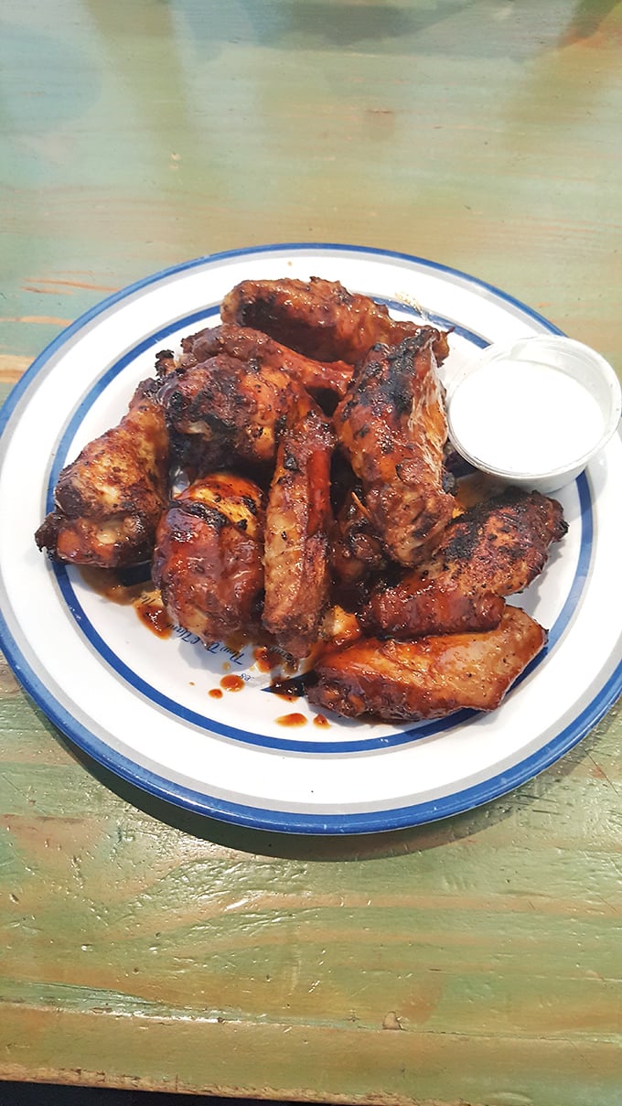 These aren't just wings – they're smoke-kissed masterpieces that make other chicken parts jealous. The blue-rimmed plate is practically a victory lap.