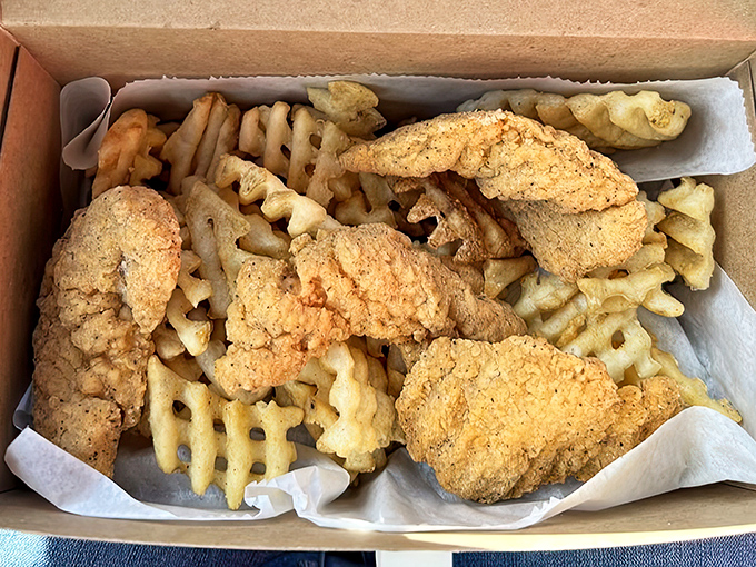Golden-brown chicken fingers that could make Colonel Sanders weep with jealousy, nestled alongside perfectly crisp waffle fries—a match made in comfort food heaven.
