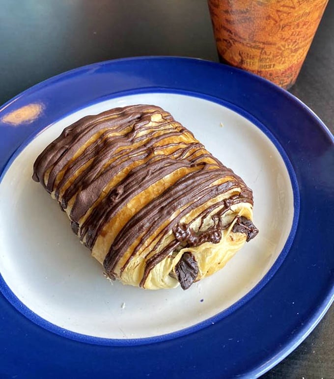 Not just any chocolate croissant – this is what breakfast dreams are made of, with chocolate drizzle that belongs in an art museum.