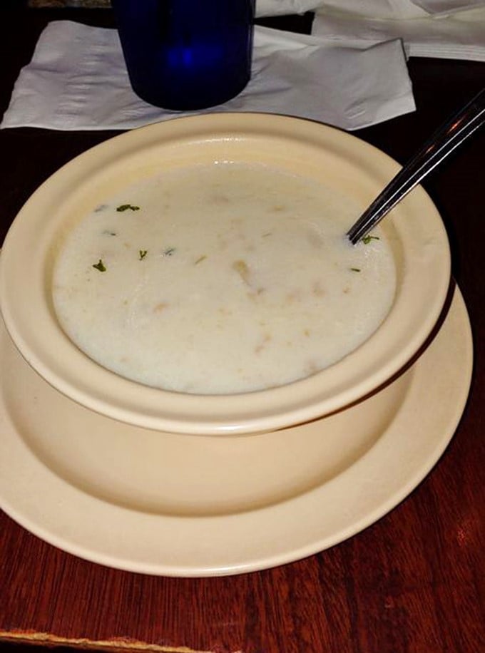 The legendary clam chowder arrives in its simple ceramic bowl, creamy and perfect, ready to convert even the most skeptical soup skeptics.