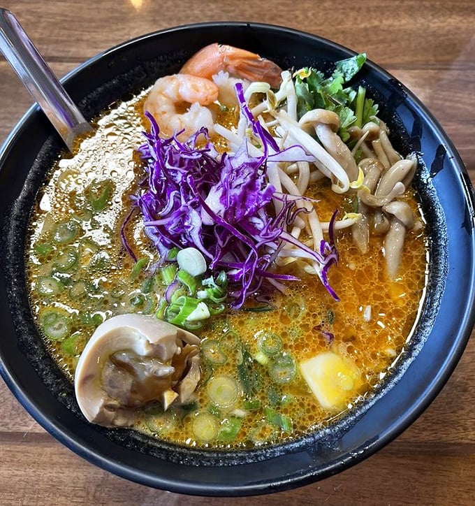 The legendary coconut curry ramen in all its glory – a sunset-colored broth cradling tender shrimp, mushrooms, and perfectly cooked noodles.