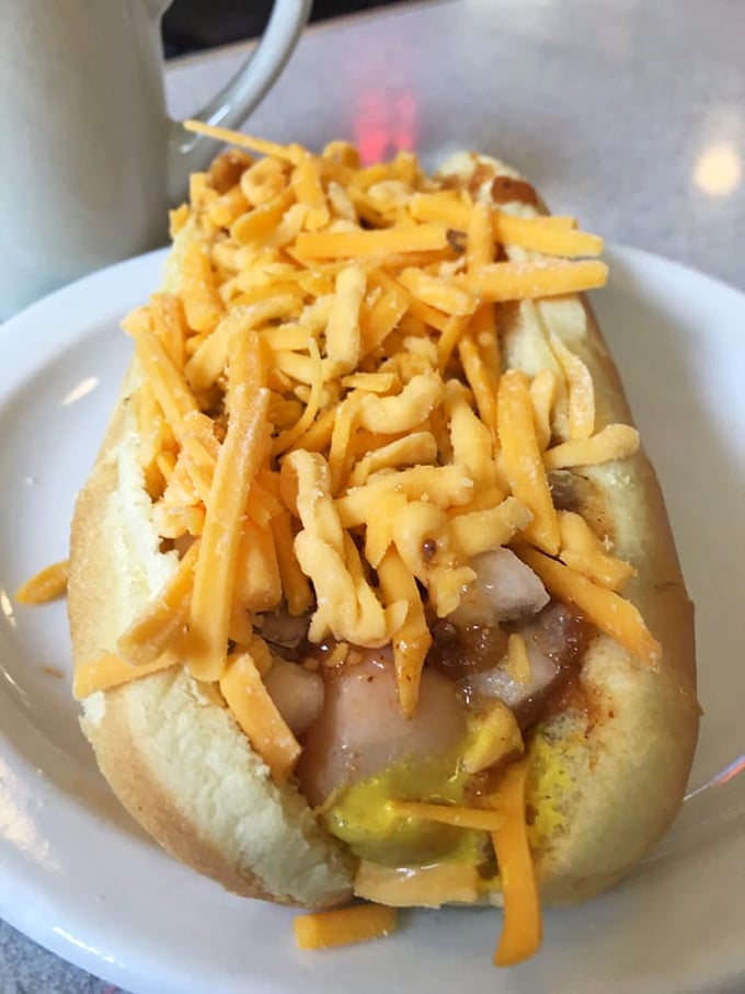 Behold the star attraction: a perfectly grilled hot dog smothered in that legendary coney sauce and crowned with cheese—simplicity perfected.