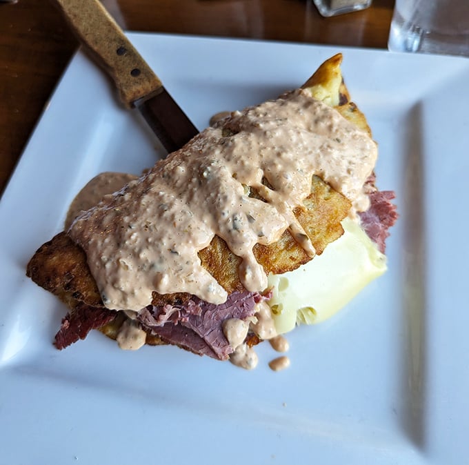 This isn't just a sandwich—it's architecture. Layers of corned beef and potatoes under a blanket of sauce that demands to be savored.