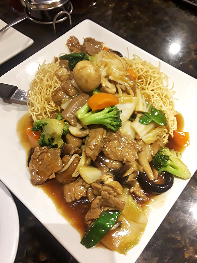 Behold the Mi Xao Don: crispy noodles topped with tender beef that achieves textural perfection most dishes only dream about.