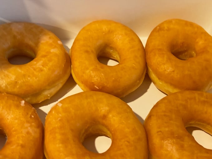 Golden-hued glazed donuts glisten with promise. These aren't just breakfast—they're edible sunshine that somehow makes Monday mornings bearable.