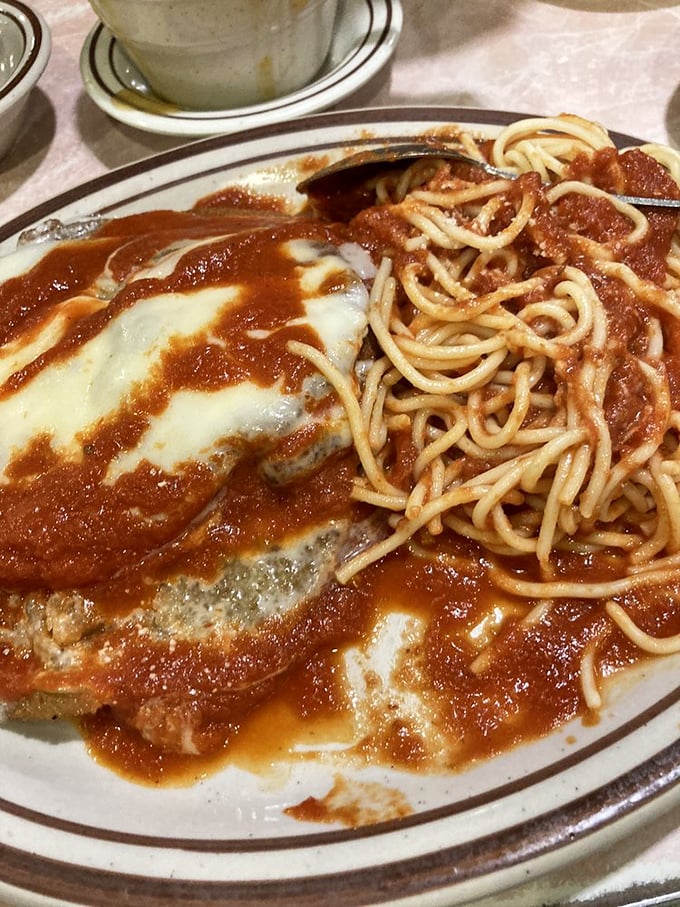 Behold the star of our show: eggplant parmigiana that achieves the holy trinity of Italian-American perfection—tender eggplant, robust sauce, and cheese that stretches for days.