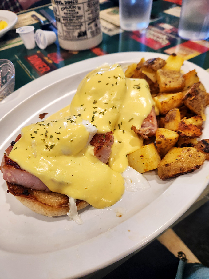 Eggs Benedict done right – golden hollandaise cascading over perfectly poached eggs and ham. Those home fries deserve their own fan club.