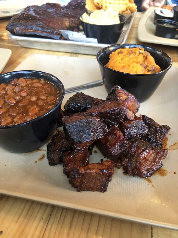 Burnt ends that would make Kansas City weep with joy, flanked by baked beans and cornbread – the holy trinity of barbecue satisfaction.